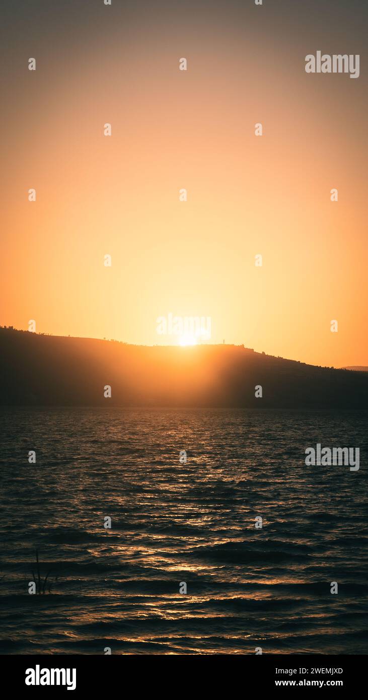 Sun peeking just over the hill Stock Photo - Alamy