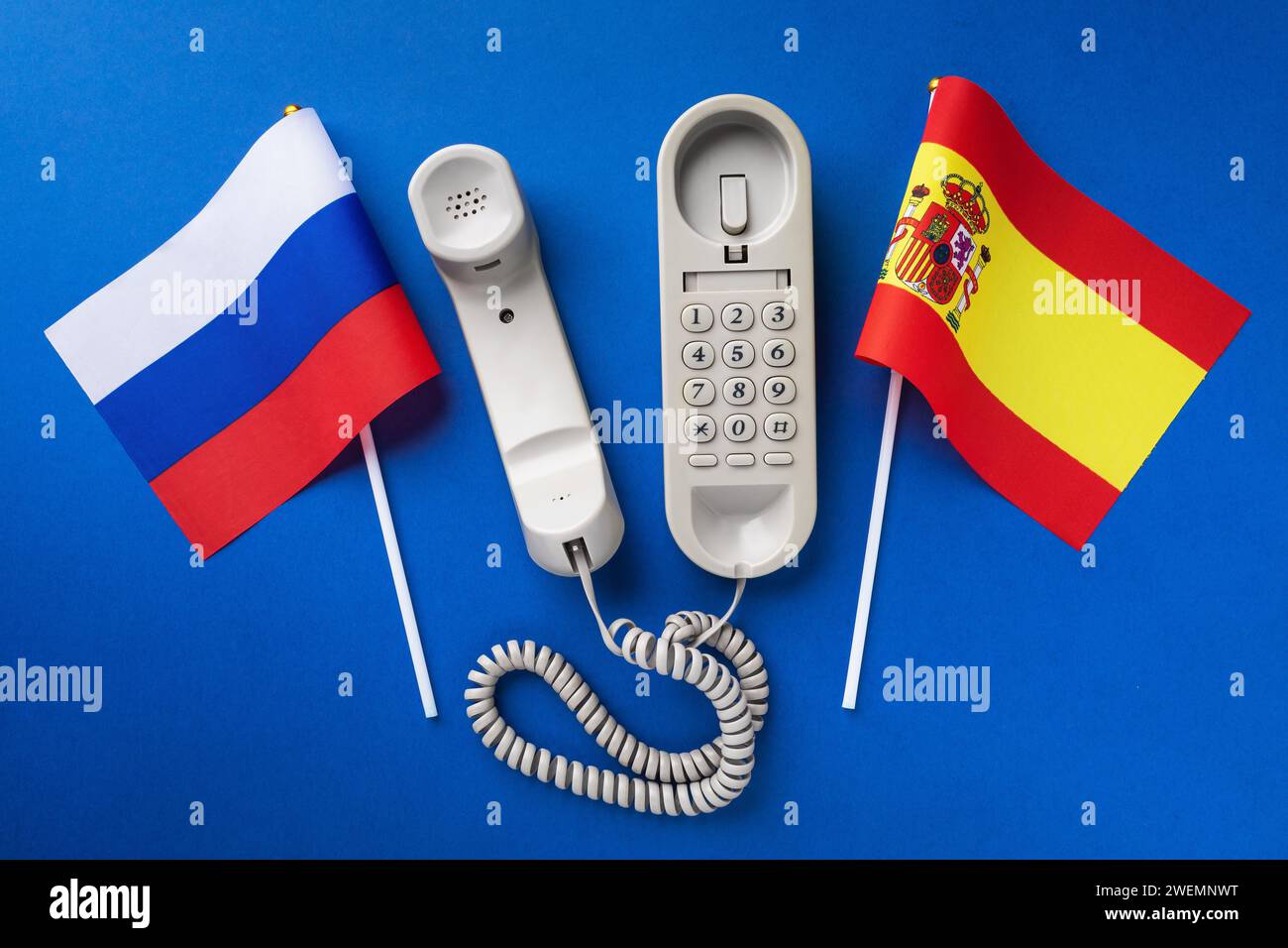Old telephone and flags of Russia and Spain on a blue background ...