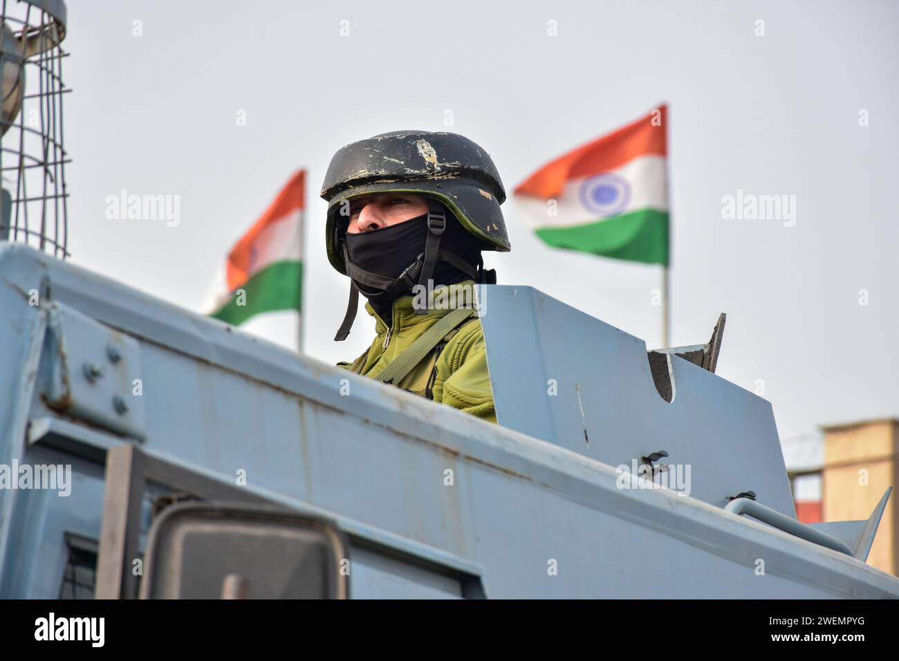A paramilitary trooper keeps vigil from the top of an armored vehicle ...