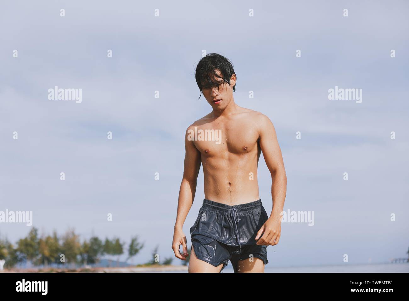 Swim, Splash, and Smiling Joy: A Young Asian Man enjoying a Tropical ...