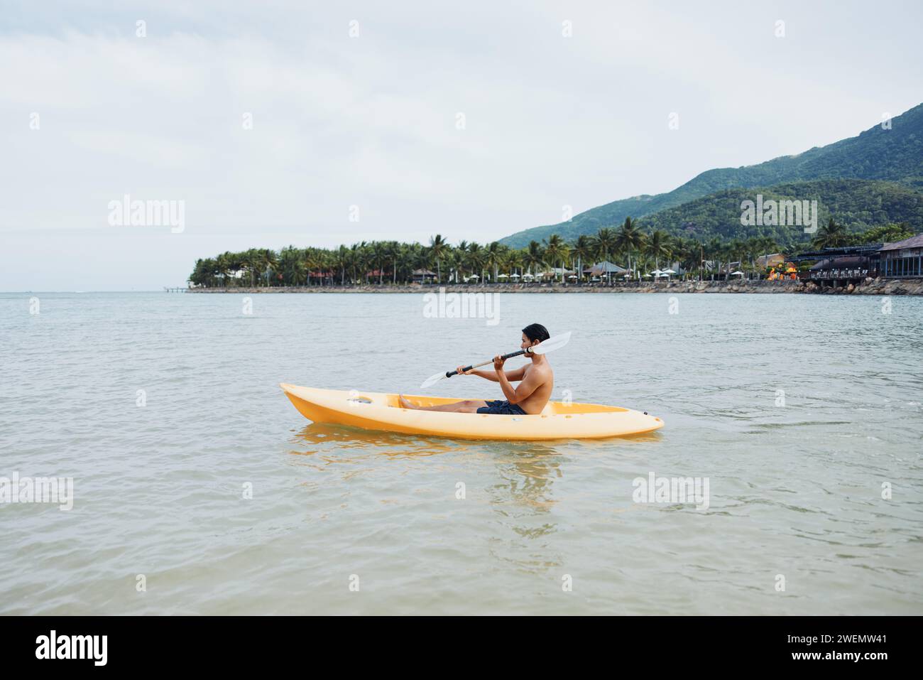 Active Asian Man Having Fun Kayaking on Tropical Beach Stock Photo - Alamy