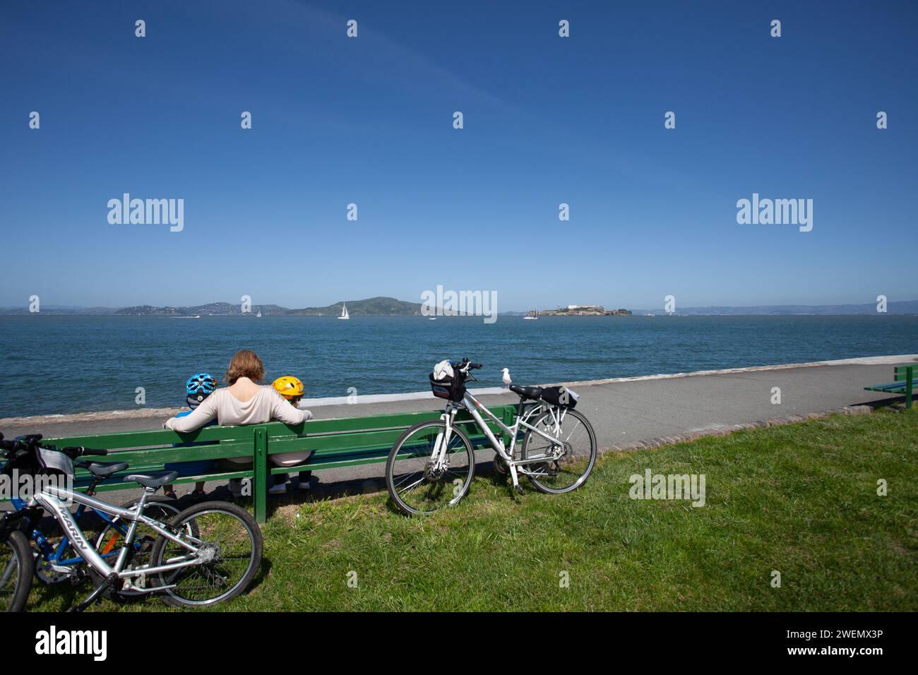 Mother and children on a park bench overlooking the pacific in San ...