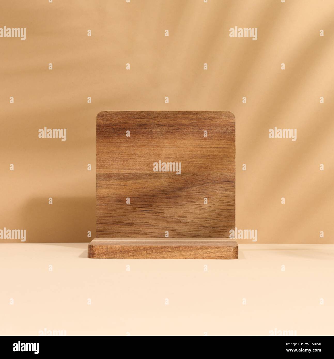 Wooden platform, shadow from a palm leaf on a brown background. Place ...