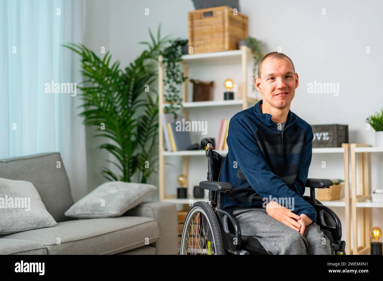 Portrait of a cheerful disabled man in wheelchair smiling at camera ...