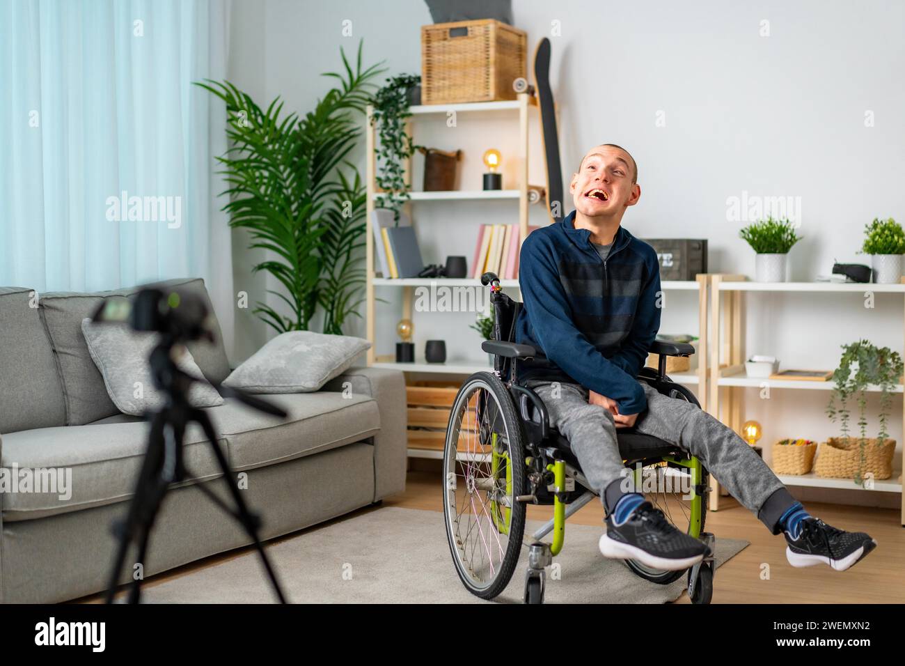 Disabled man recording a video tutorial at home using a digital camera ...