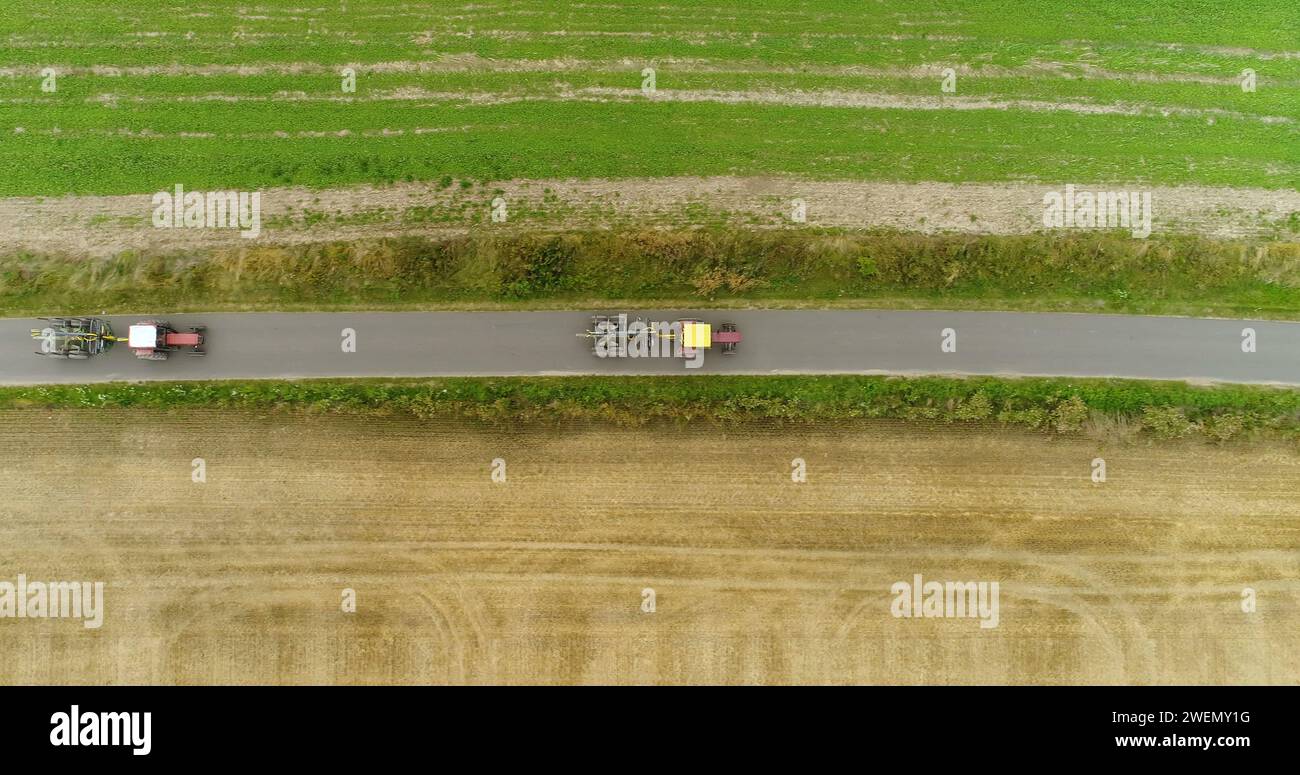 Aerial view of tractor passing road. Agricultural tractor workin on field Stock Photo - Alamy