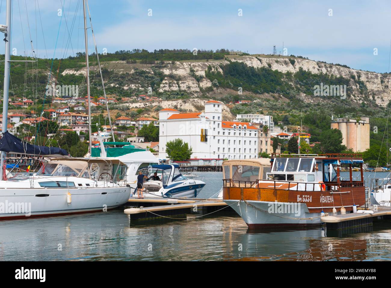 A view of the harbour with various boats and a coastal town, Balchik ...