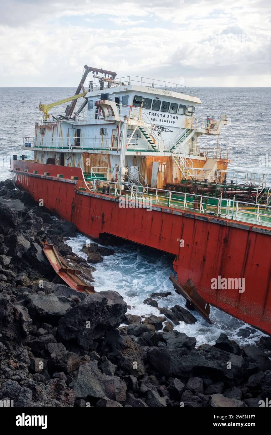 A large shipwrecked Tresta Star boat rests on the rocky shore of ...