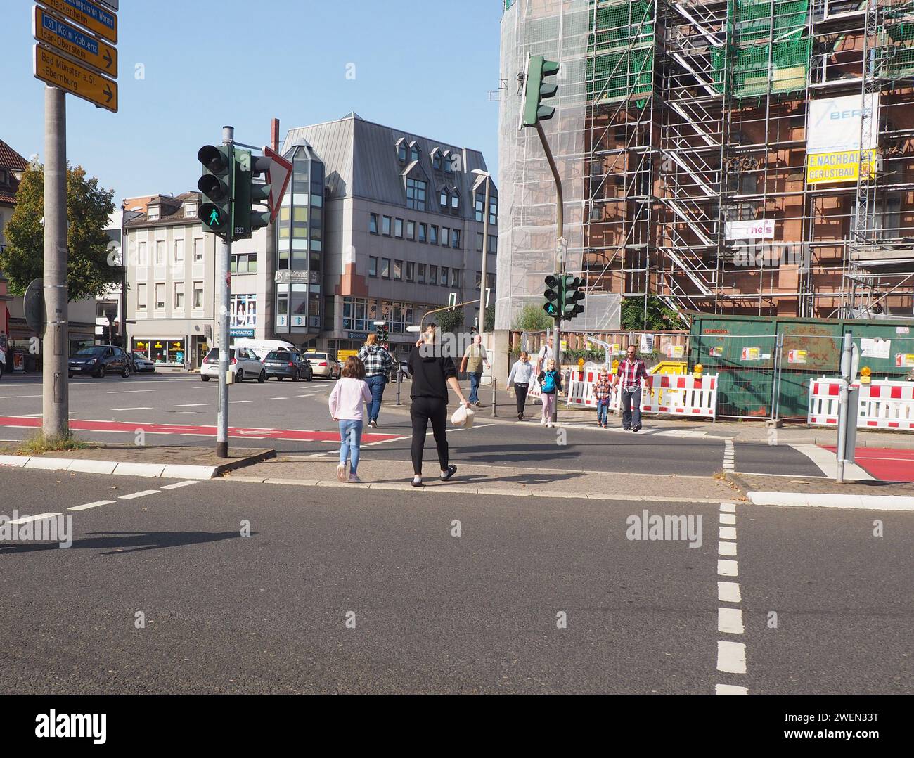 Pedestrians and children cross main street at intersection during green ...