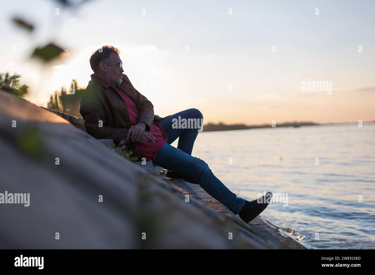 lonely man sitting on stairs next to the river bank Stock Photo - Alamy