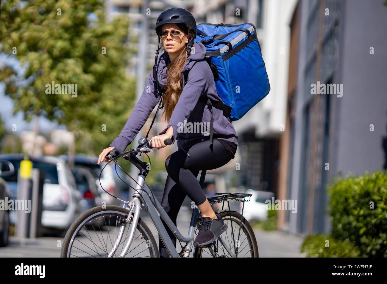 delivery person riding electric bicycle Stock Photo - Alamy