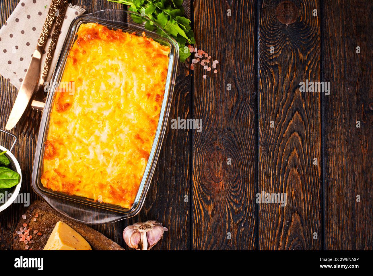 Rectangular glass bowl filled with mashed potato, underneath which is ...