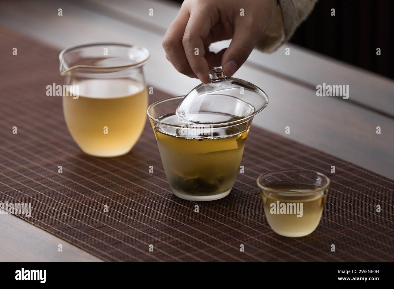 Image of tea set, person making Asian-style tea, tea cup and teapot ...