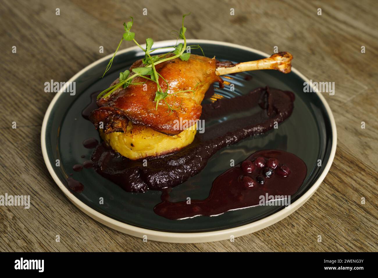 Roasted duck leg on mashed potatoes with onion, purple cabbage cream ...