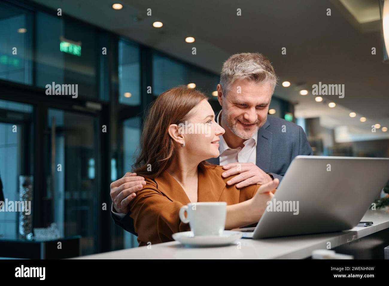 Happy lady and man watching something on laptop Stock Photo - Alamy