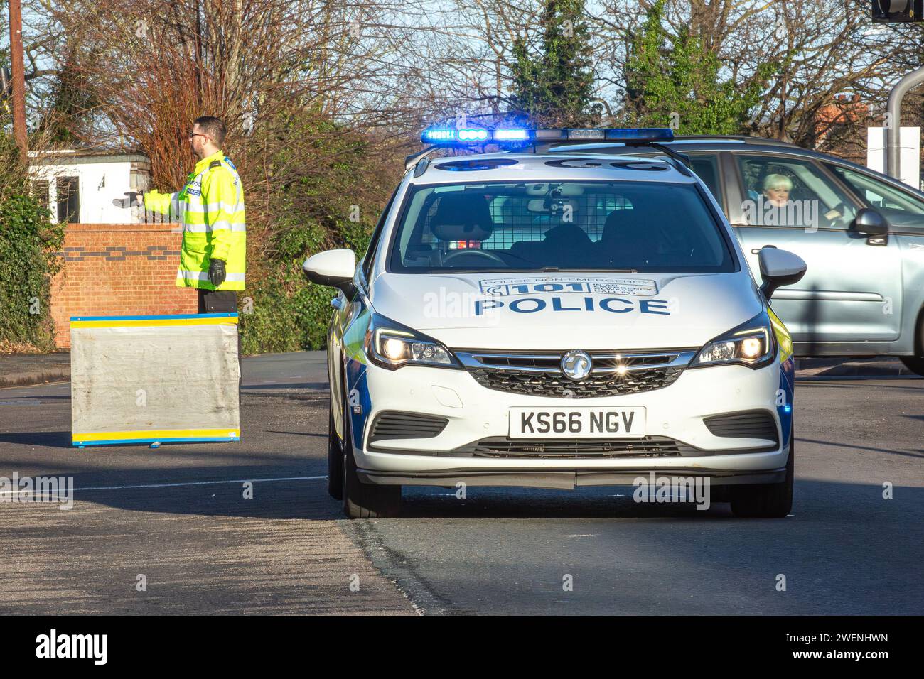 Front view of a police car with flashing blue lights and a police man ...