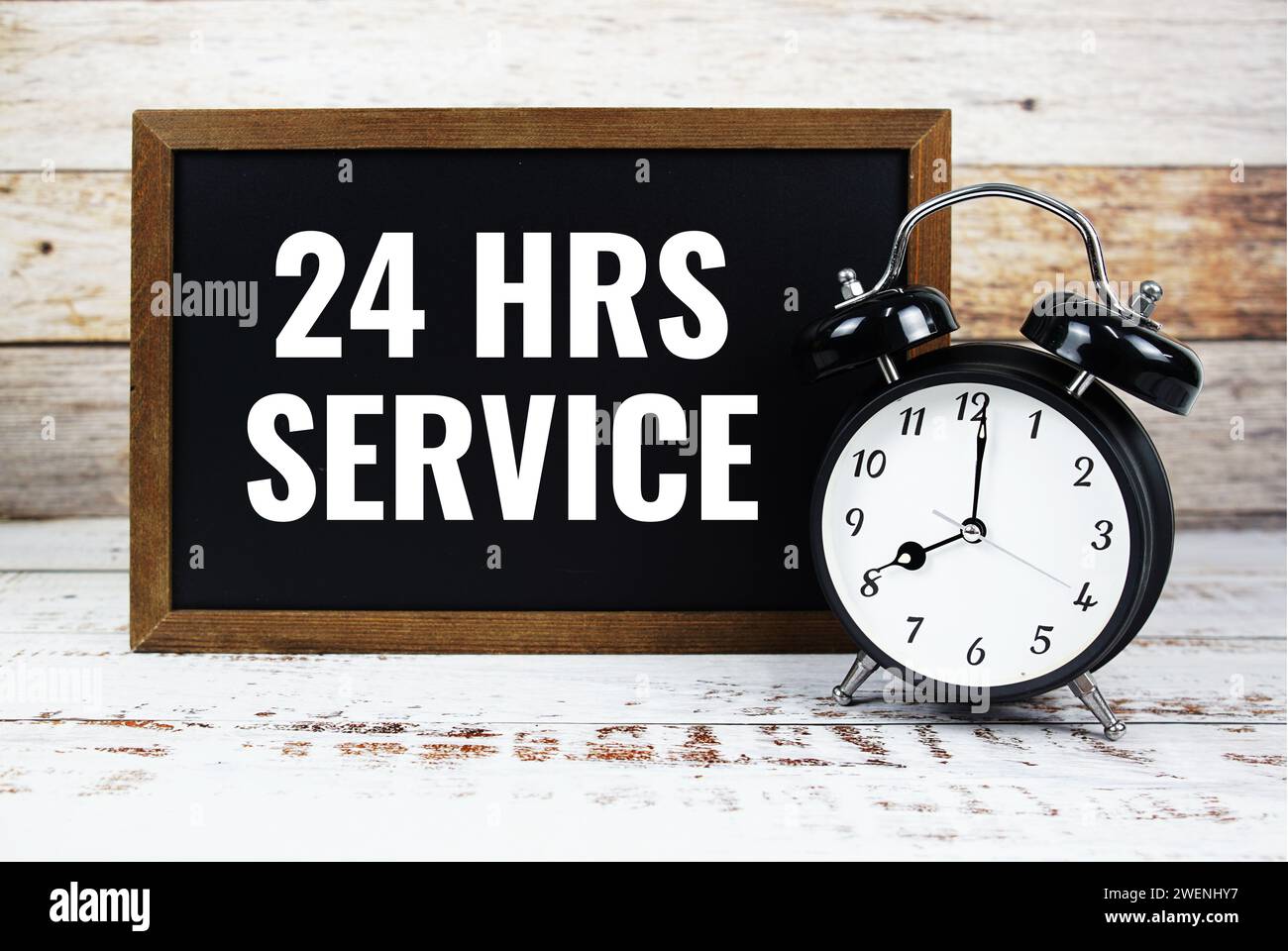 24 HRS Service text message with alarm clock on wooden background Stock ...