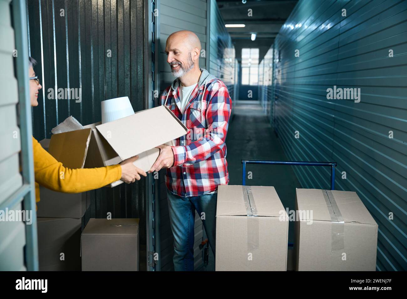Adult guy passes things in a box to a woman Stock Photo - Alamy