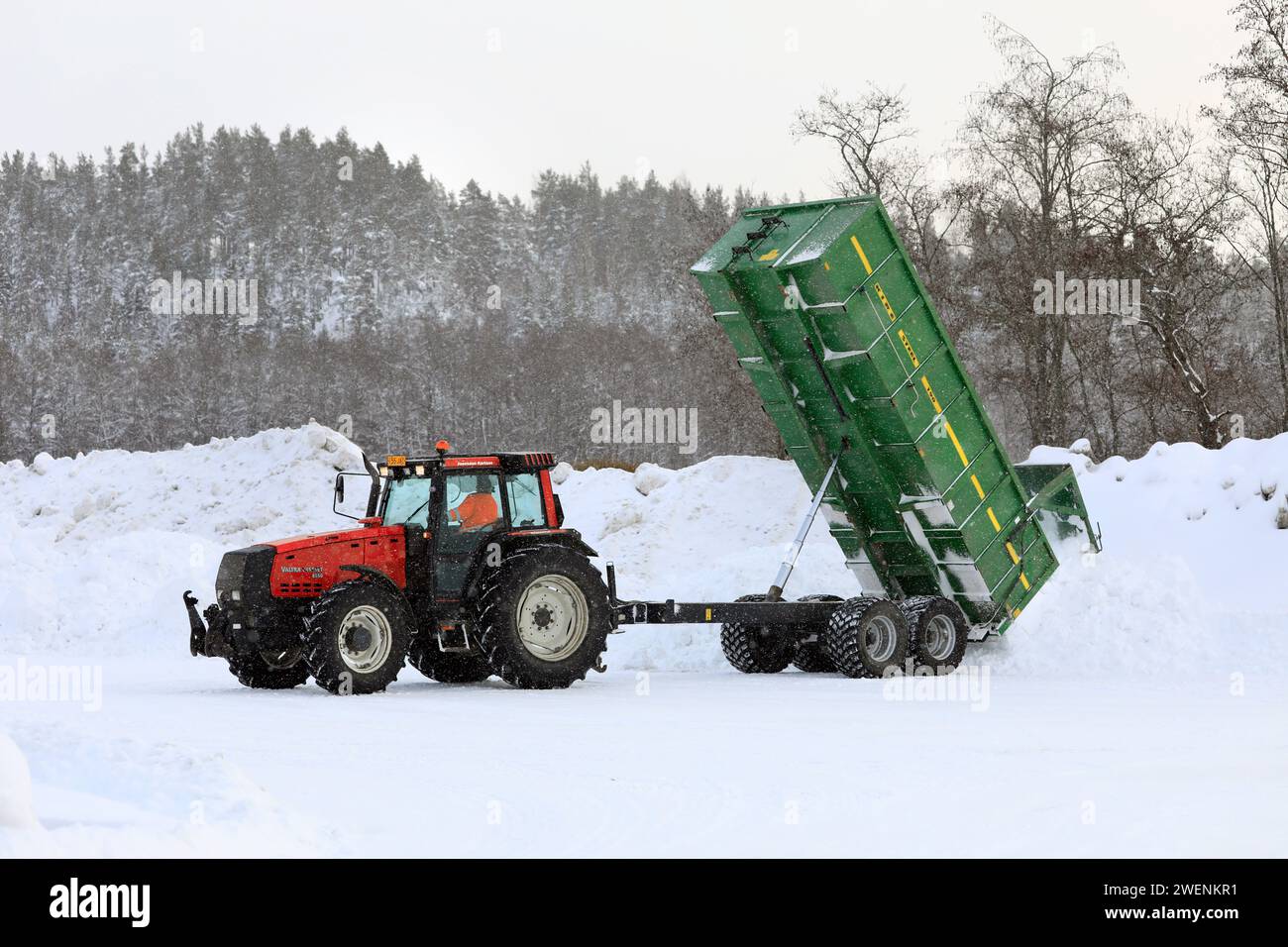 Red Valtra Valmet 8550 tractor unloads trailer load of snow cleared ...