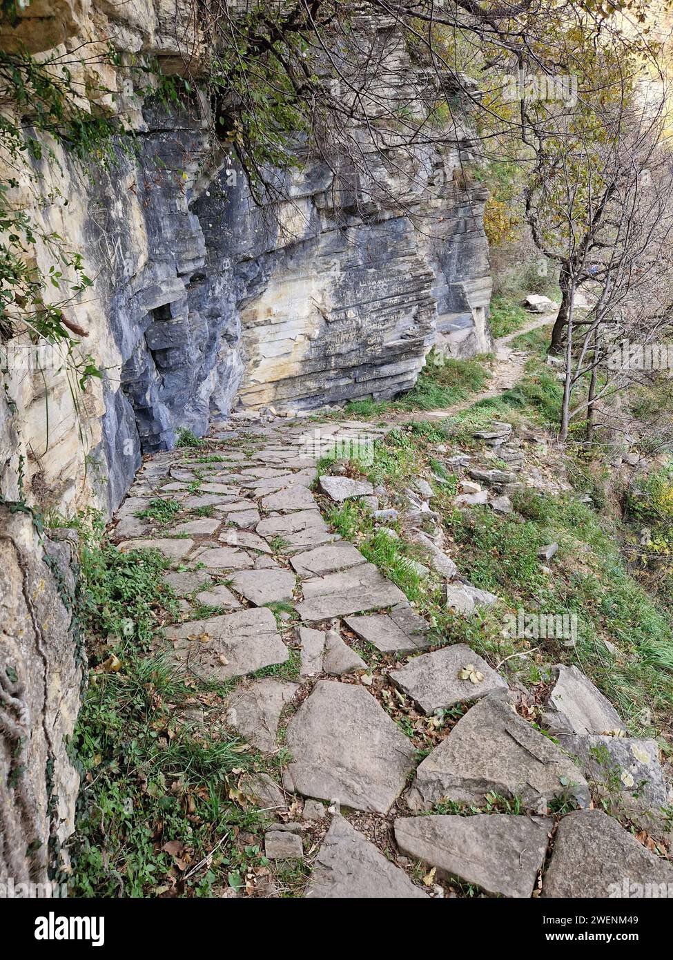 A stone pathway gracefully traverses the side of a majestic hill Stock ...