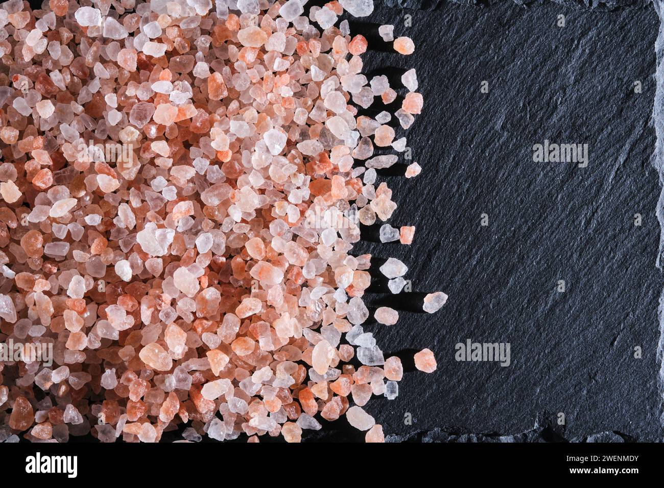 Crystals of pink edible Himalayan salt on background slate stone Stock ...