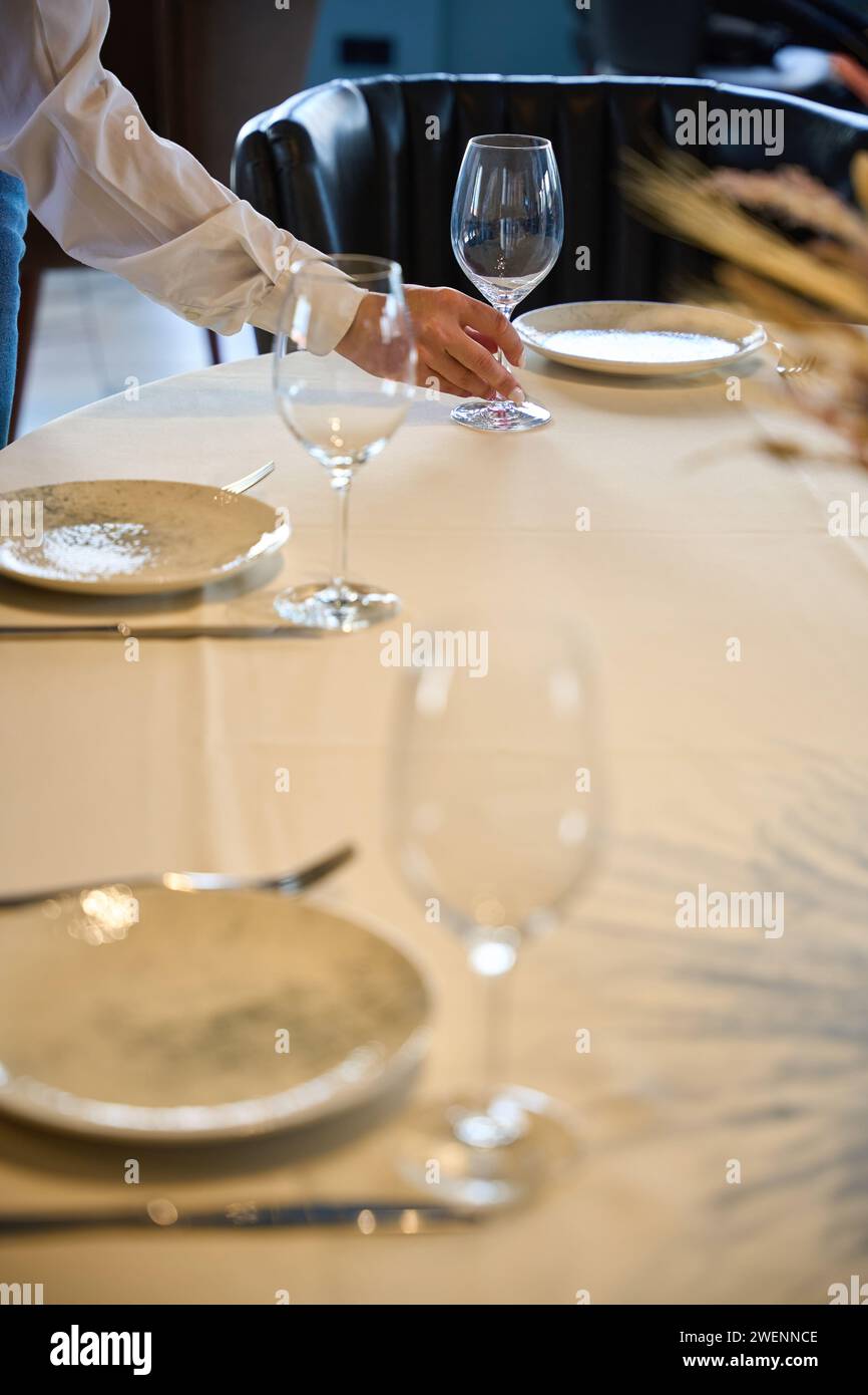 Waitress in white jacket serves a table in restaurant hall Stock Photo ...