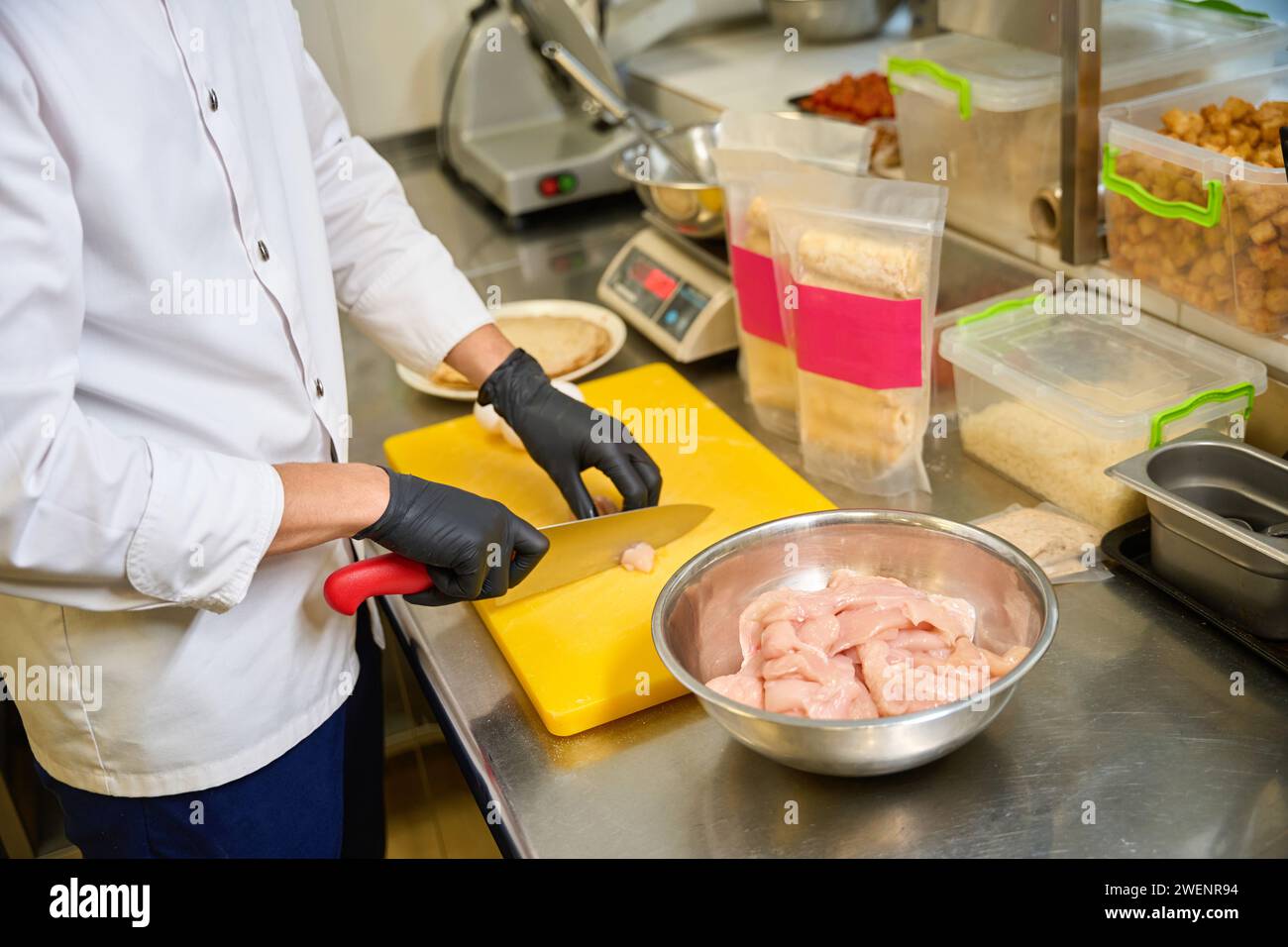 Kitchen staff cuts chicken fillet on a cutting board Stock Photo - Alamy