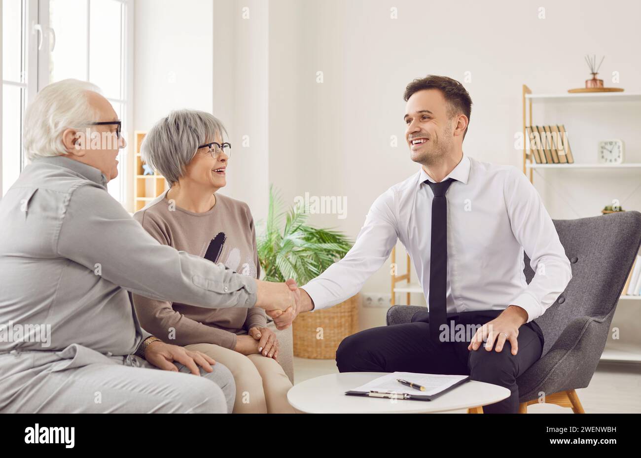 Senior pair and young consultant handshake providing care, giving ...