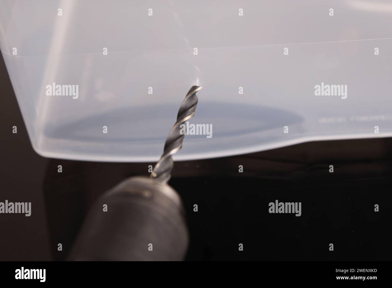 Drilling air vent hole into plastic storage box Stock Photo - Alamy