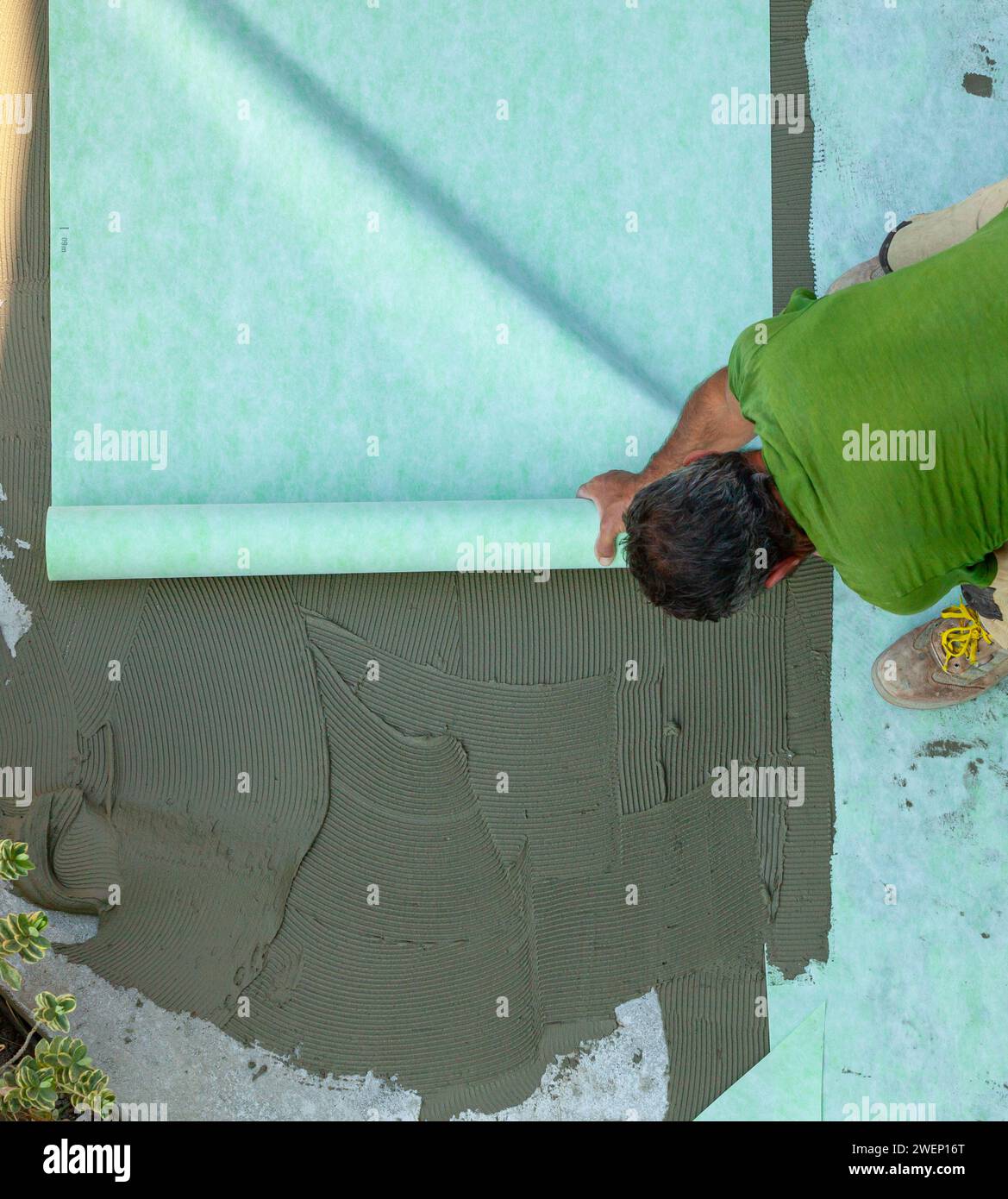 Laying a sound-absorbing mat on the screed Stock Photo - Alamy
