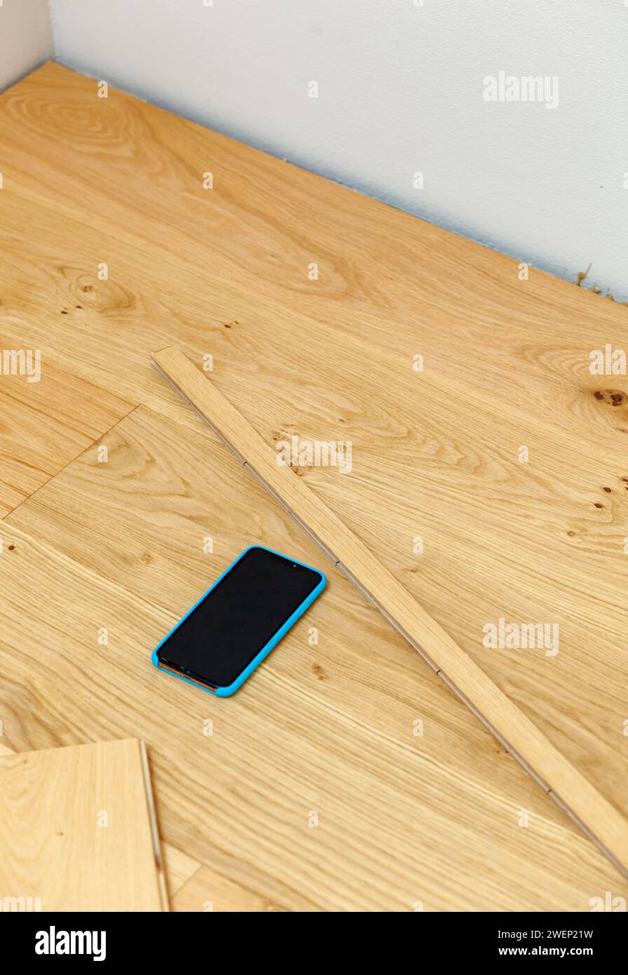 Smartphone on the parquet during its installation. Telephone contact ...