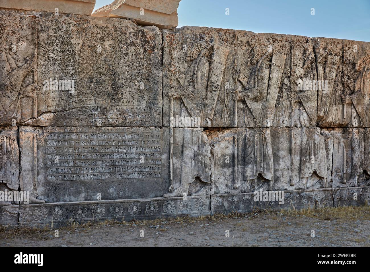 Badly damaged reliefs and cuneiform inscriptions on platform of ruined ...