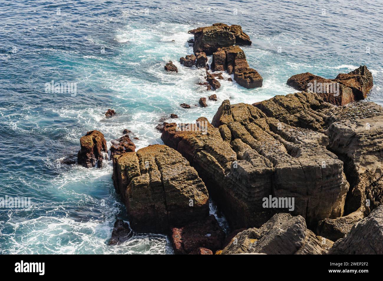Striking layered rock formations along the rugged coast of Northern ...