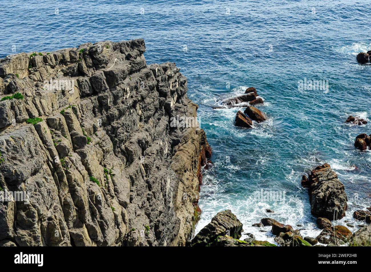 Striking layered rock formations along the rugged coast of Northern ...