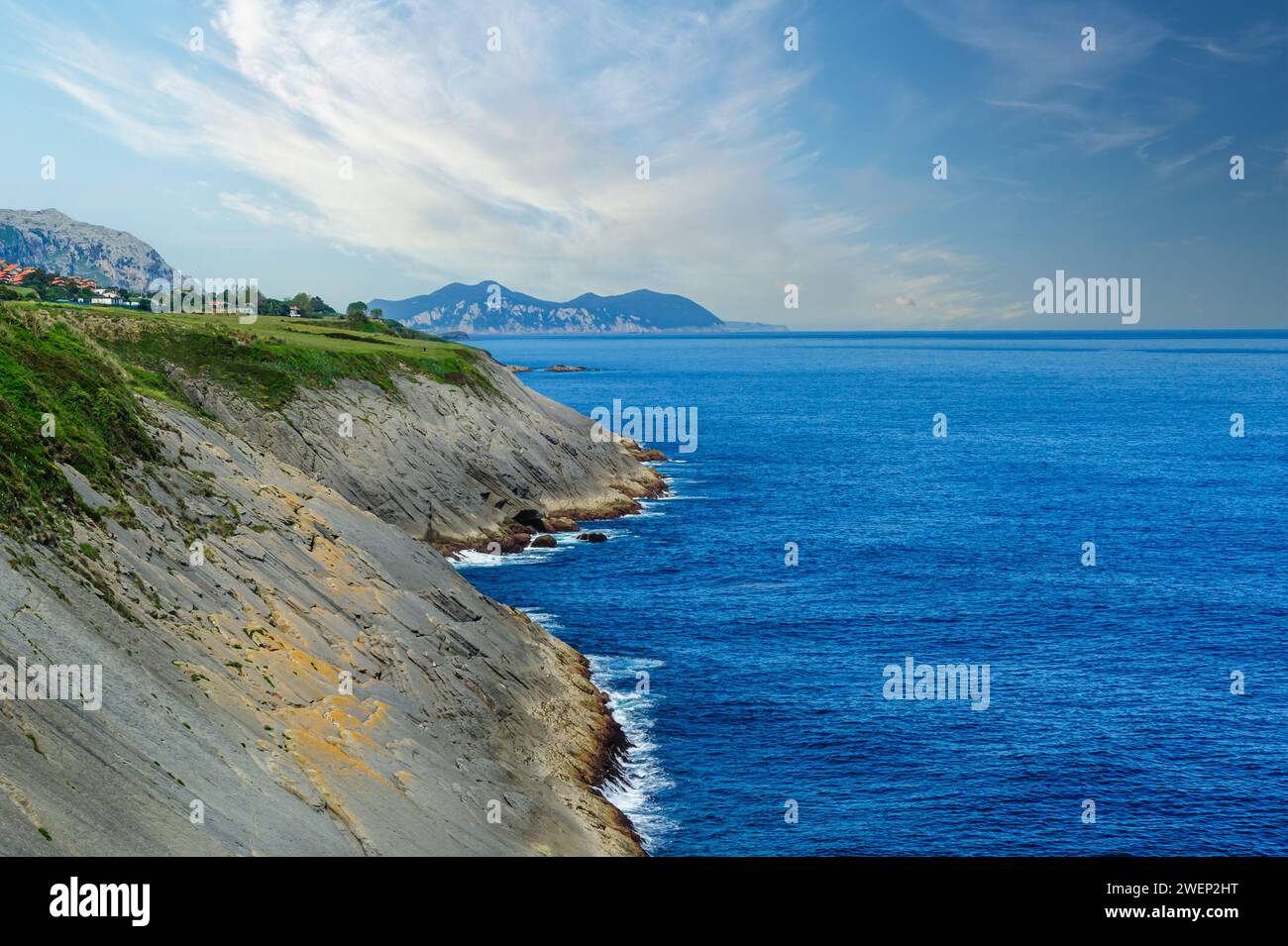 Striking layered rock formations along the rugged coast of Northern ...