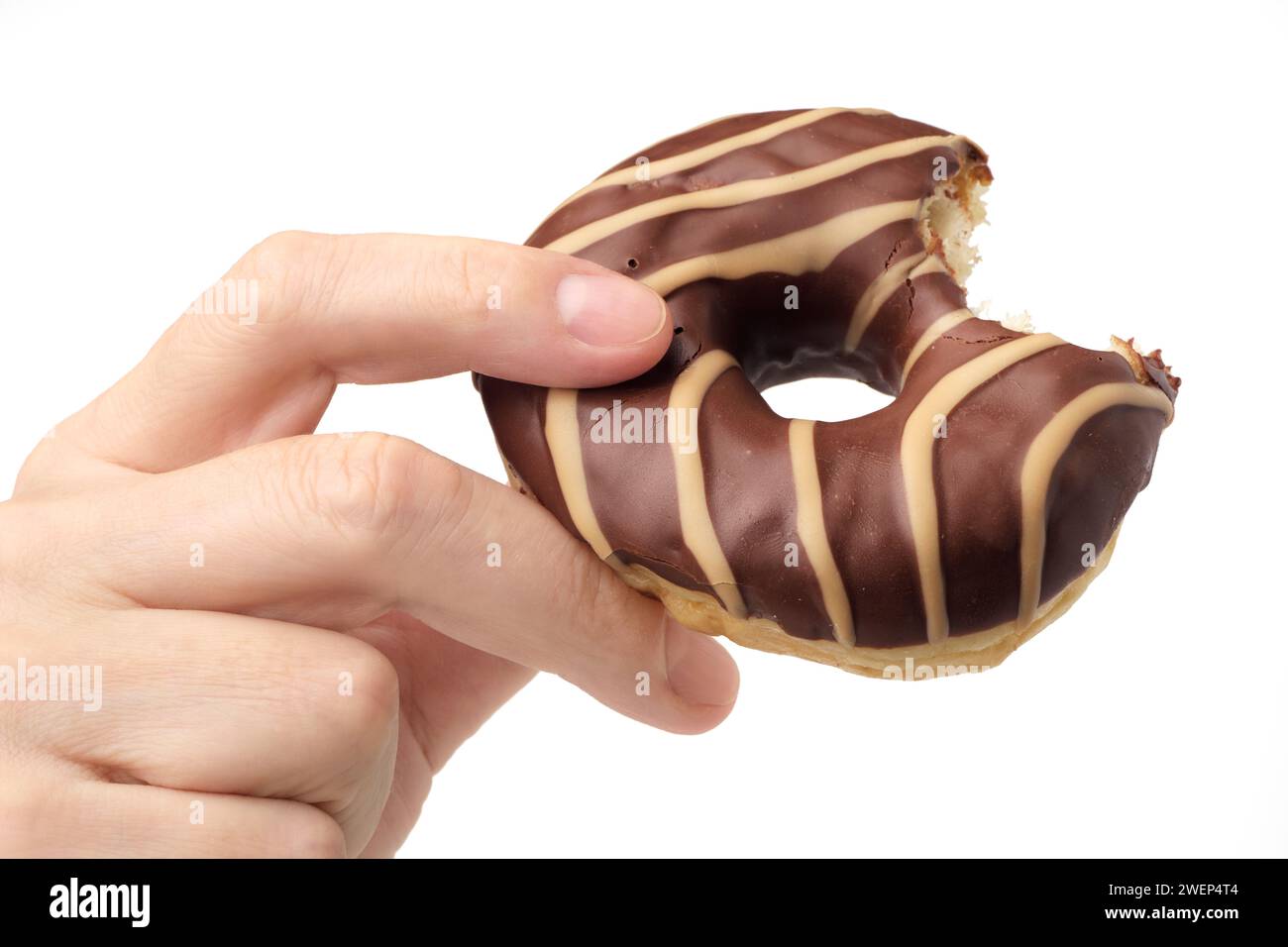 Human hand holding bitten striped chocolate and caramel donut, isolated ...