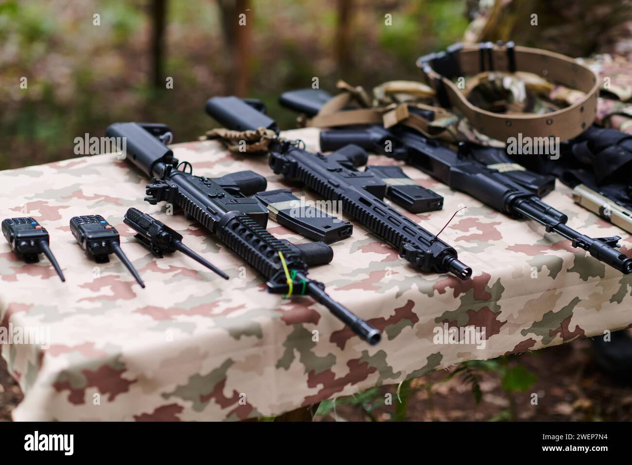 An array of military weapons, including rifles and pistols, is ...
