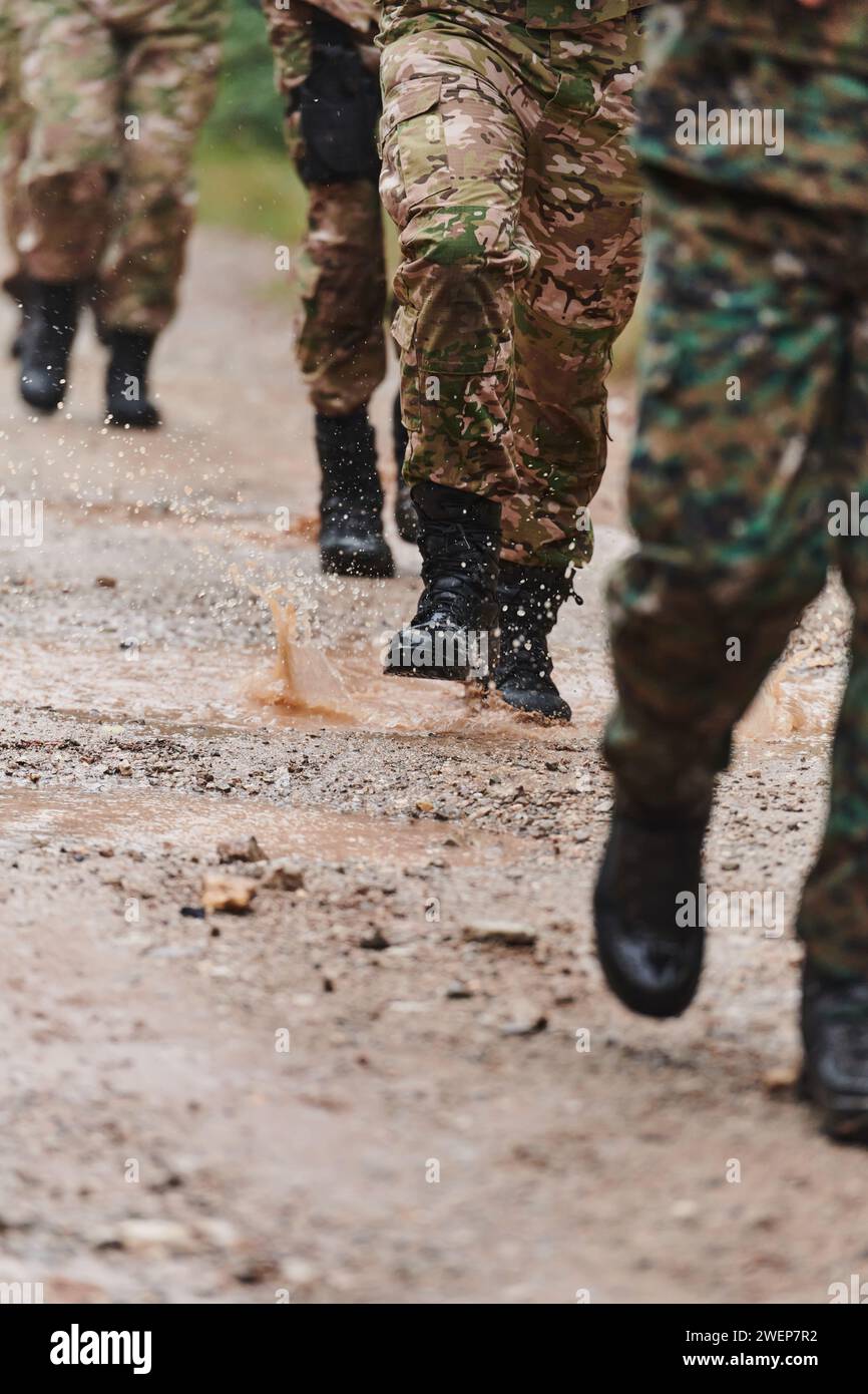Close up photo, the resilient legs of elite soldiers, clad in camouflage boots, stride ...