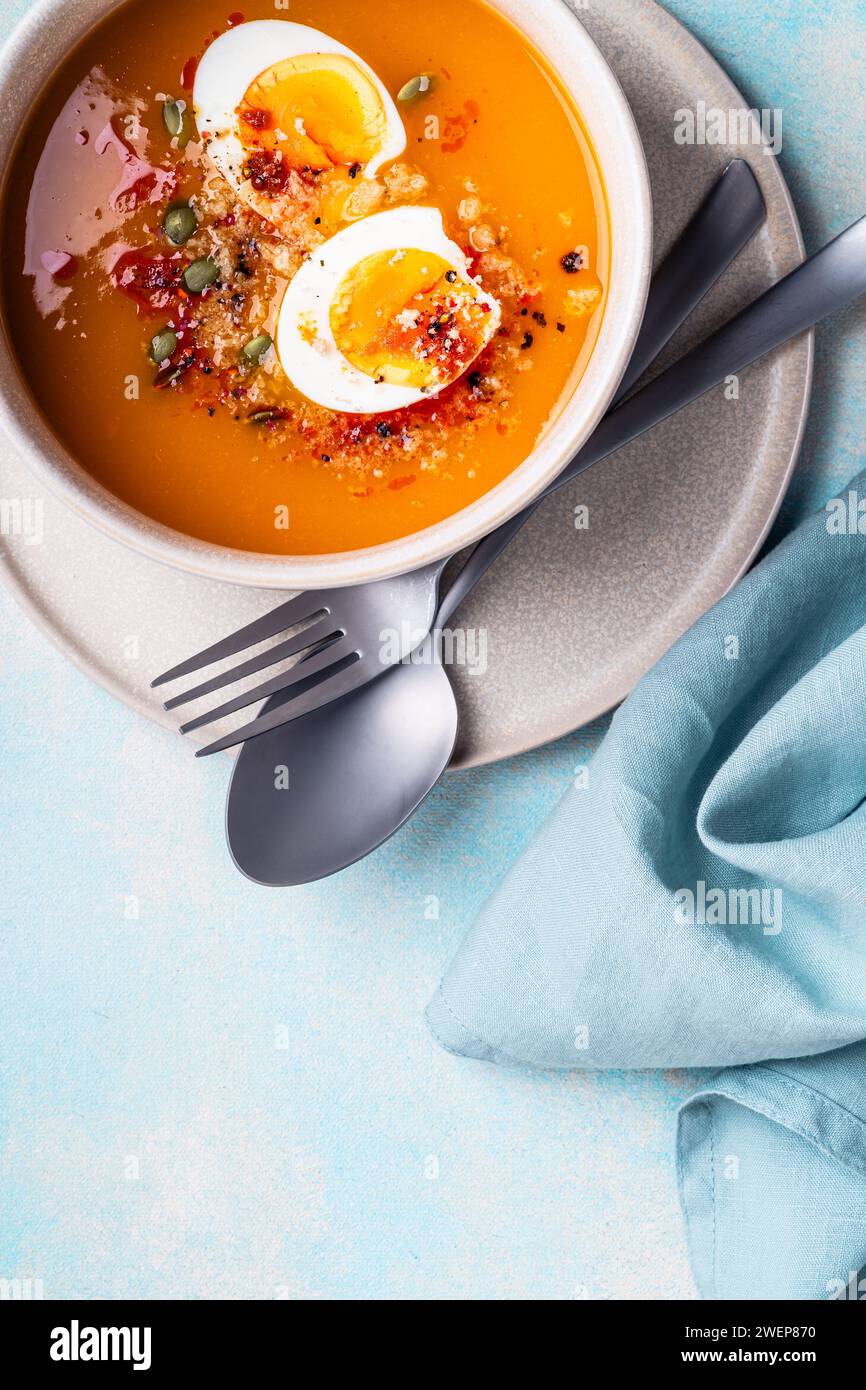 Butternut squash and carrot soup with boiled egg, autumn or winter creamy delicious healthy food ...