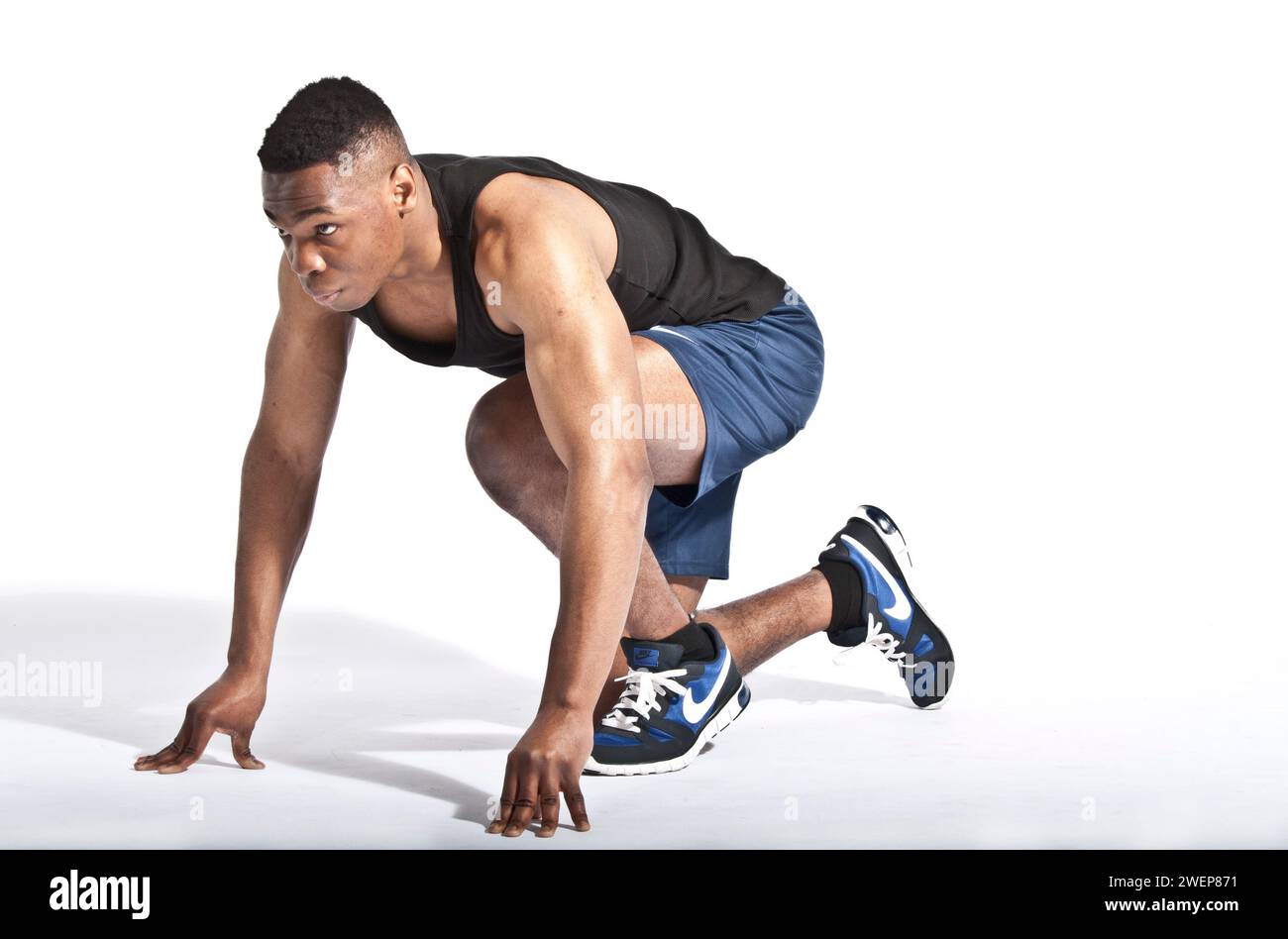 A young black British man in a sprint start Stock Photo - Alamy