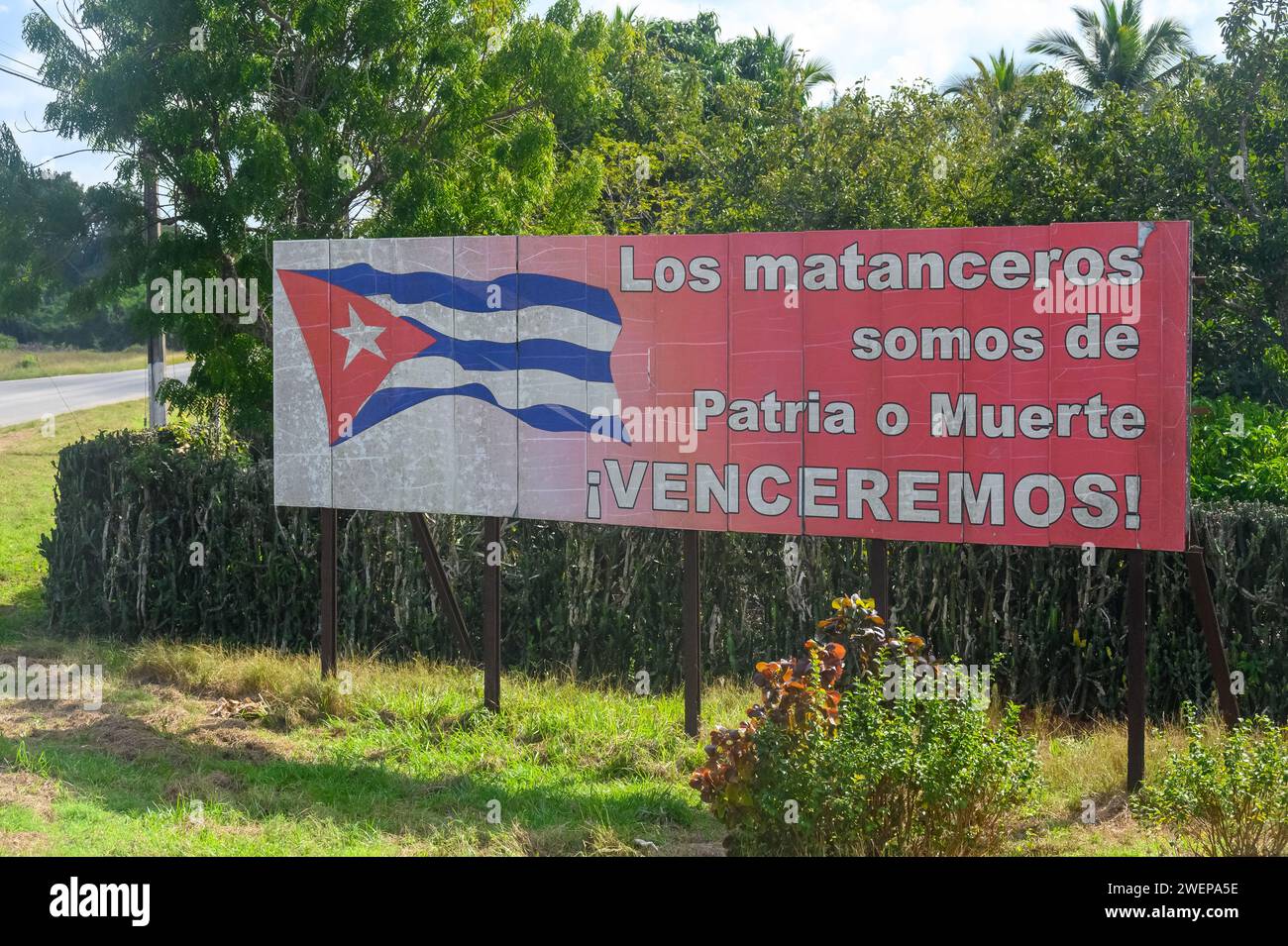 propaganda billboard and a cuban flag, cuba. it reads, people from ...