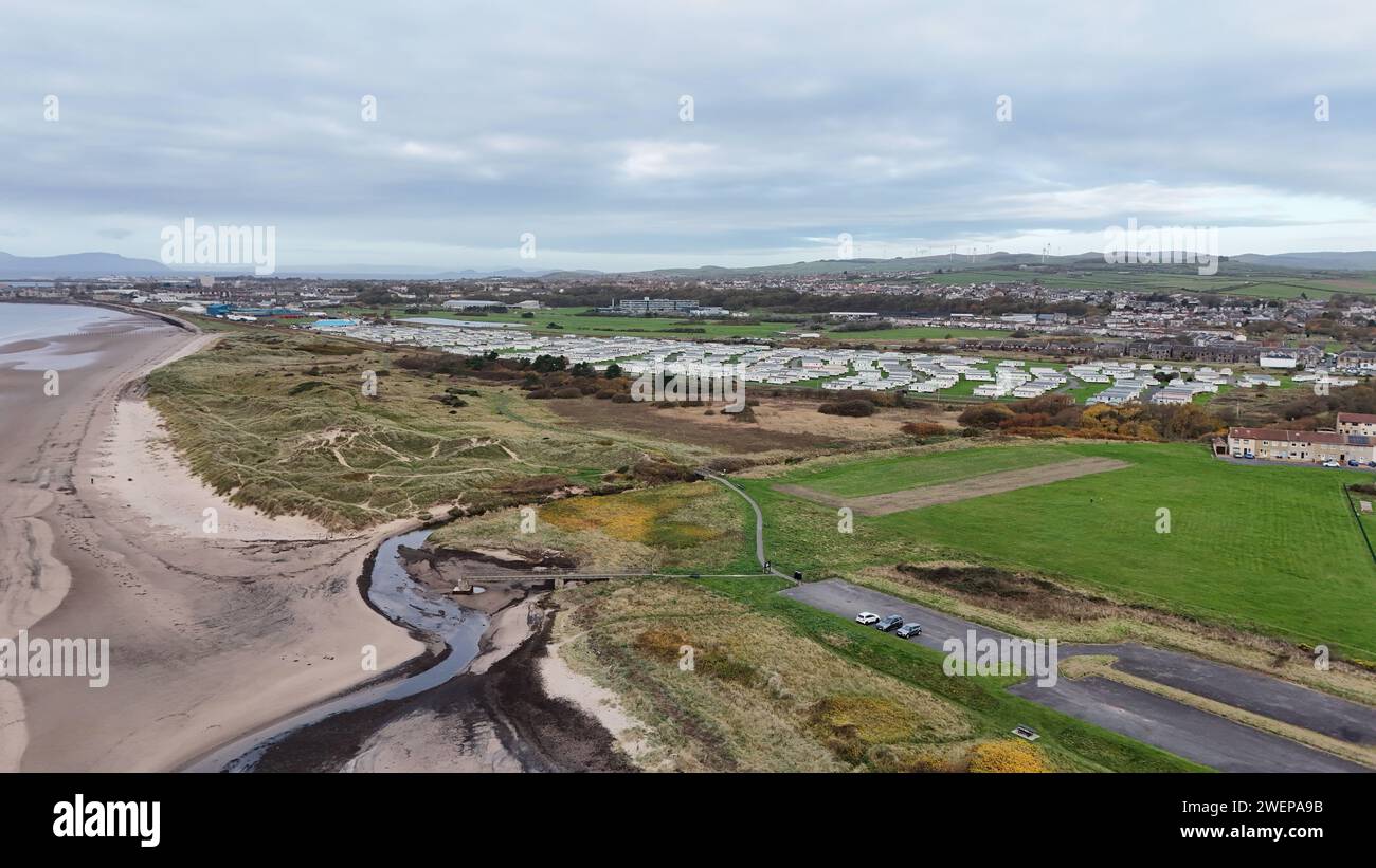 Wide bay with houses along the shore and a meandering road descending ...