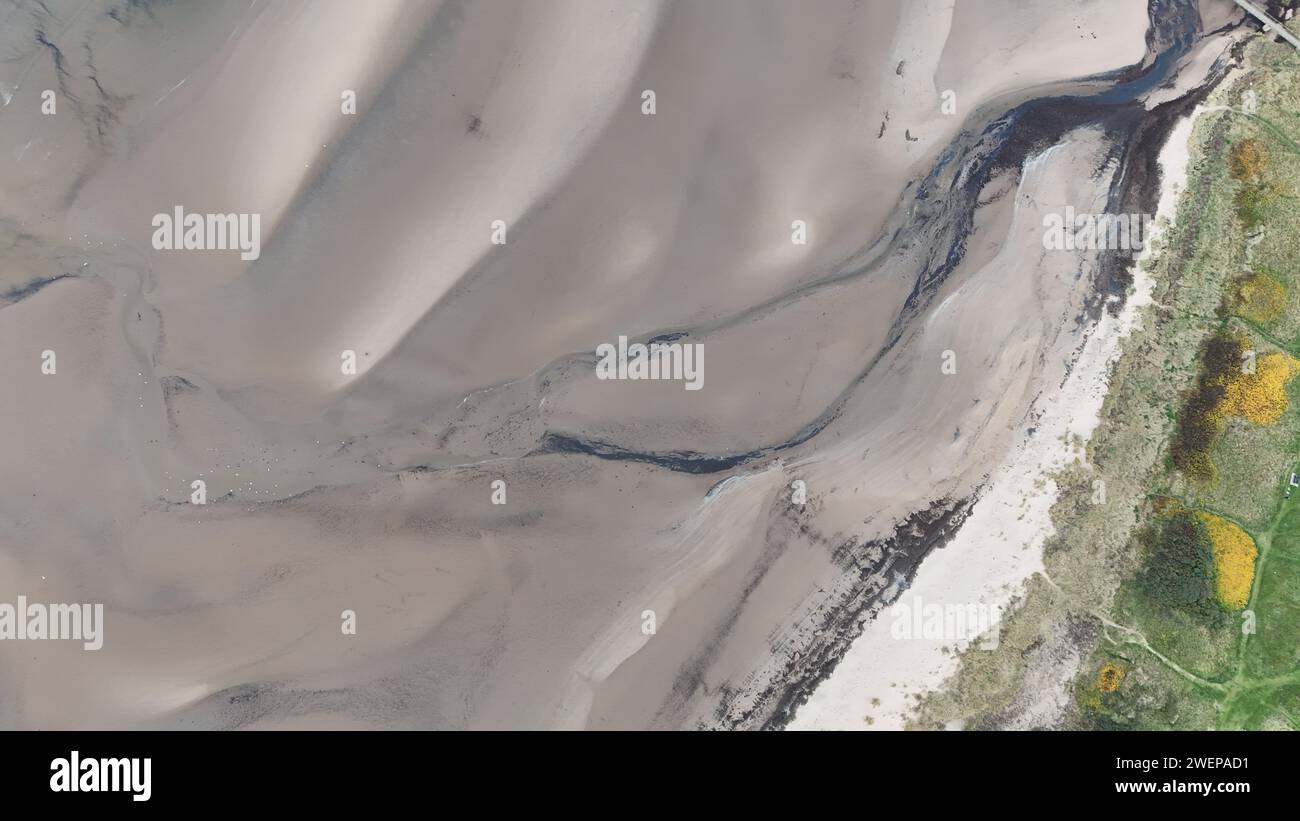 A scenic coastal landscape featuring sandy terrain and lush foliage ...