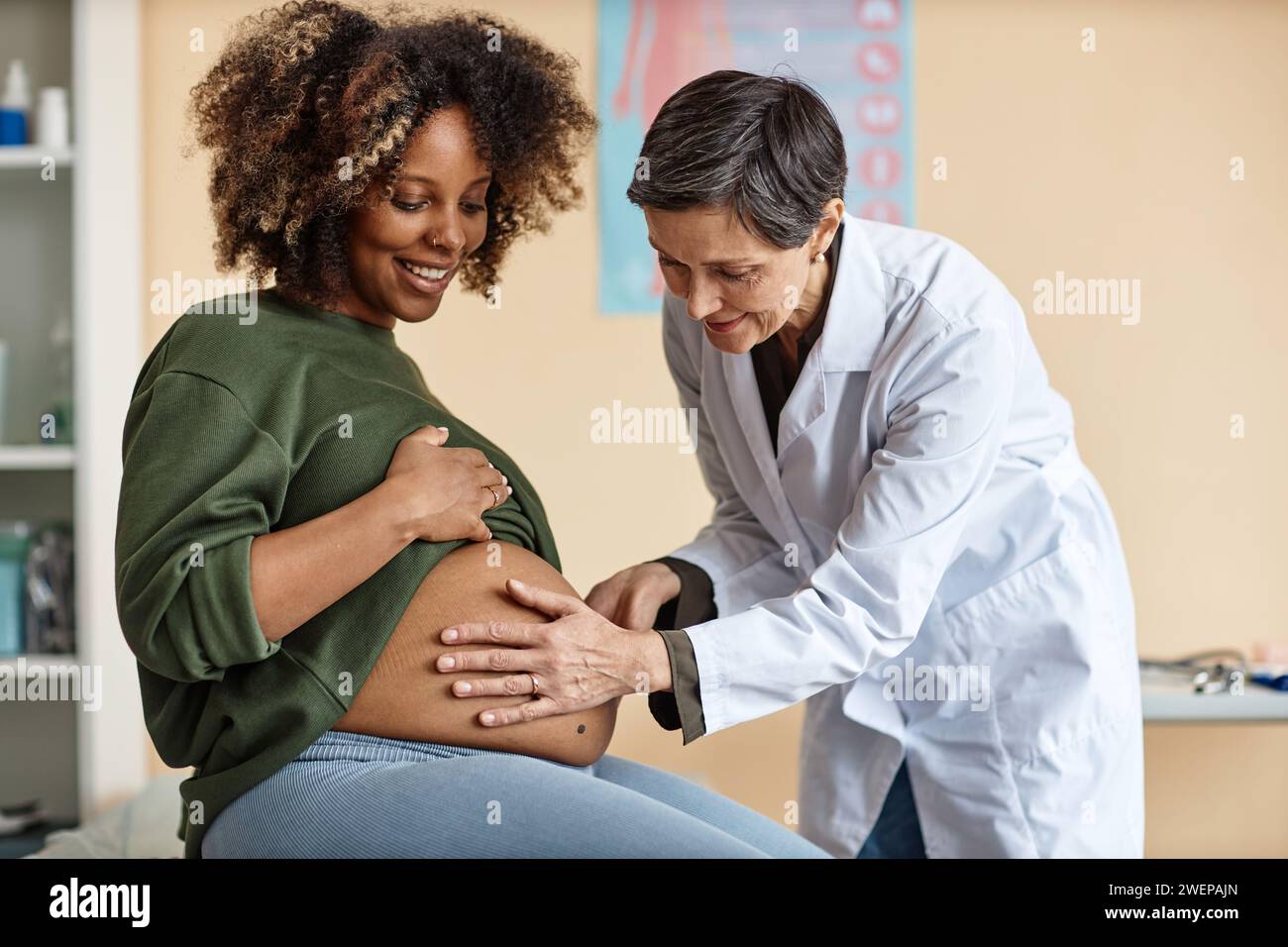 Female Obstetrician Checking Expectant Mothers Belly Stock Photo - Alamy