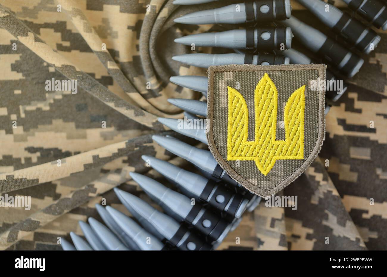 Ukrainian army symbol on machine gun belt lies on ukrainian pixeled ...