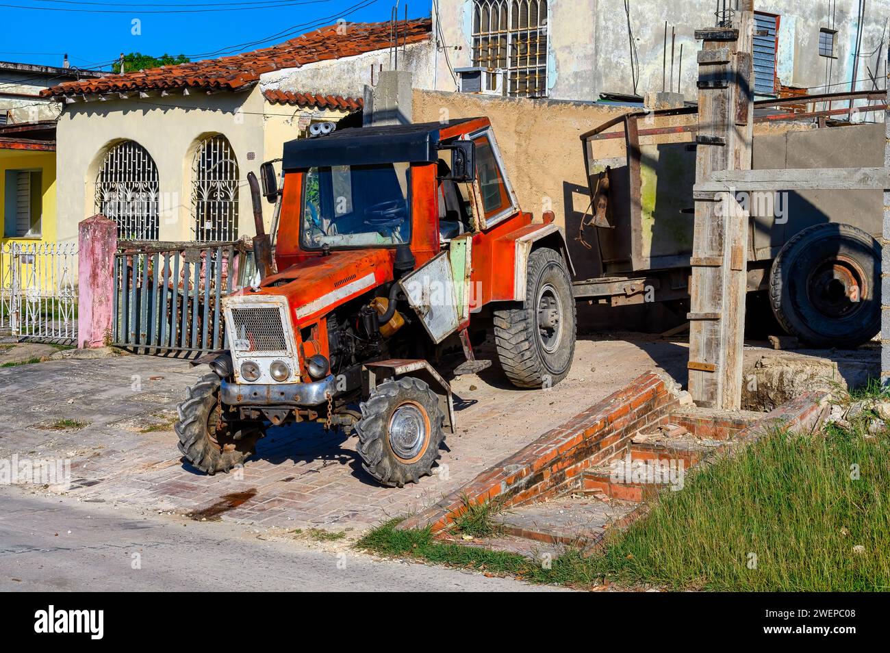 Old agricultural tractor in a ramp by houses, Cuba Stock Photo - Alamy