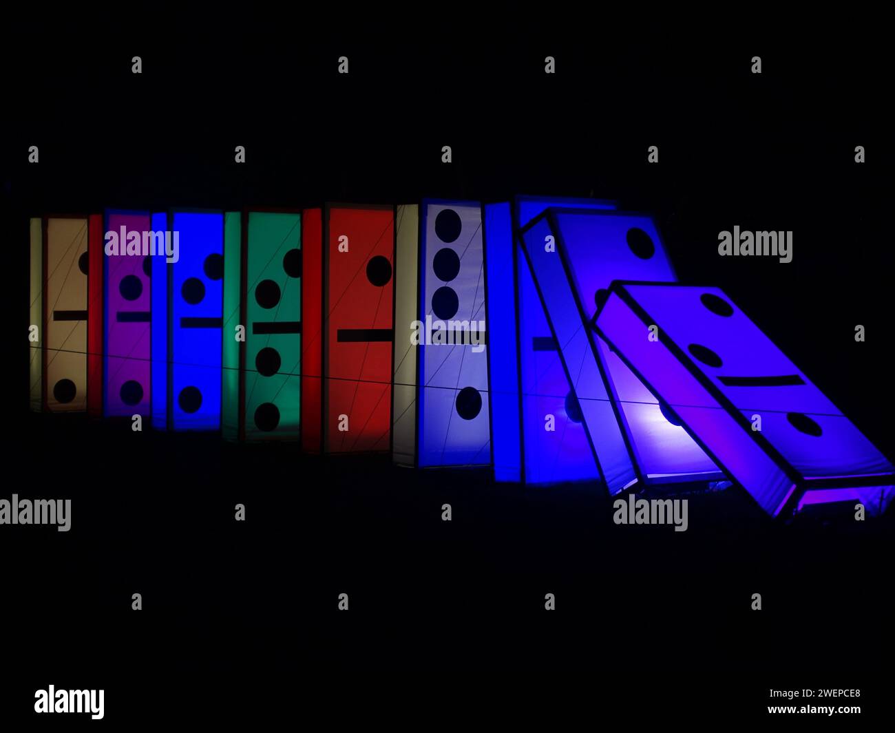 Illuminated dominos glowing in darkness with vibrant lights on black ...
