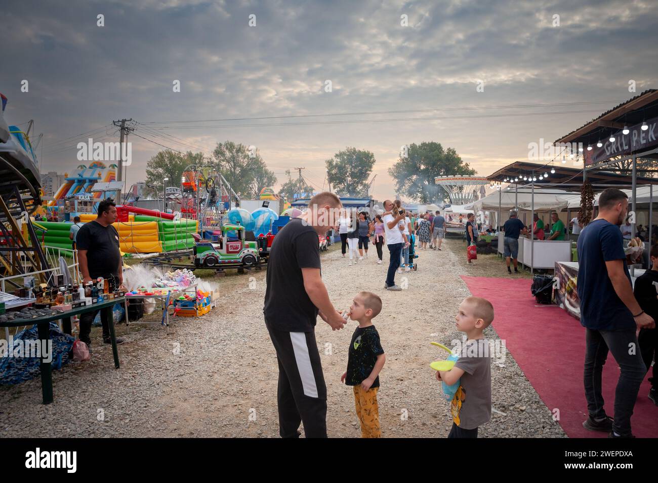 Picture of people, a father and his kids, boys, eating pljeskavica, a ...