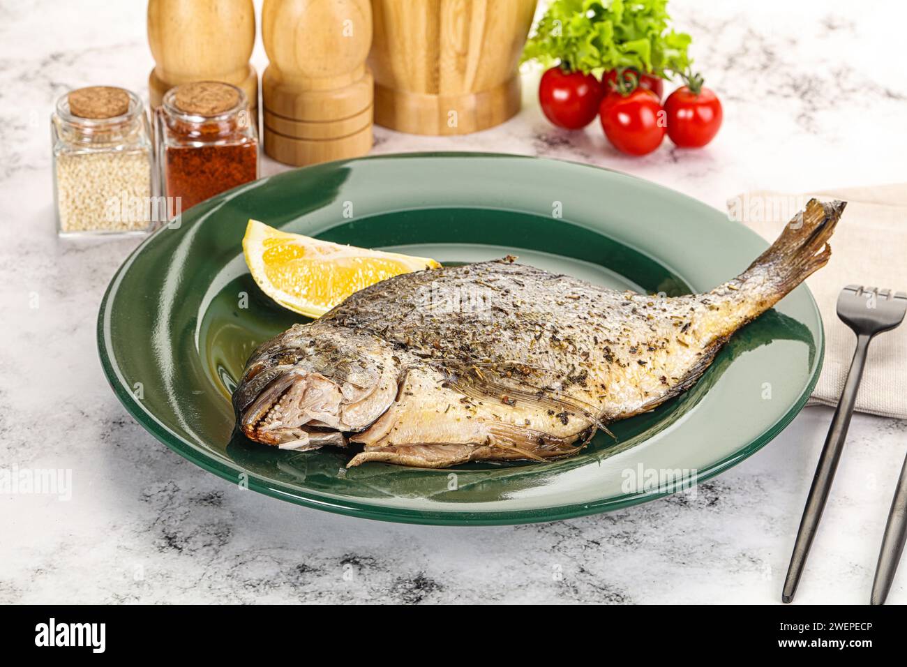 Baked Dorado fish served lemon slice Stock Photo - Alamy