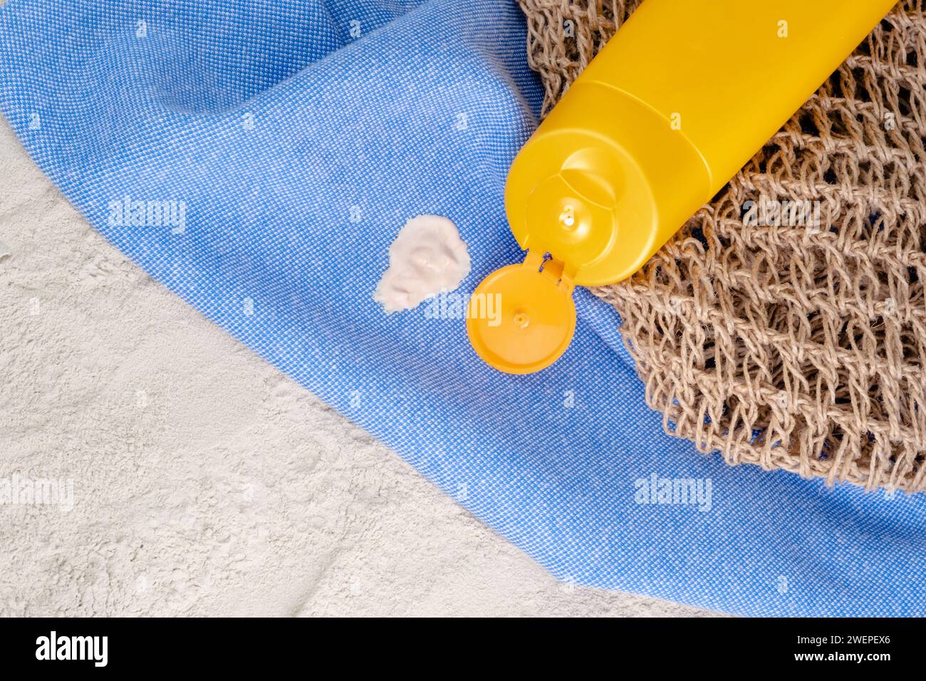 Dirty stain of spilled cream on clothes on the beach. White skin care ...